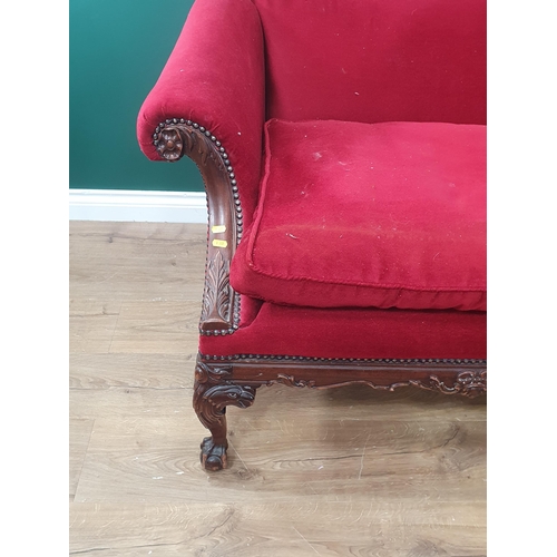 A carved and upholstered camelback Settee raised on squat carved ...