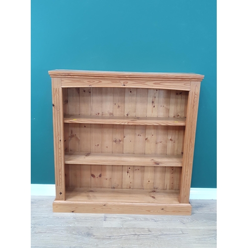 A pine Open Bookcase with moulded cornice, two fitted shelves and raised on plinth base, 3ft 7"High