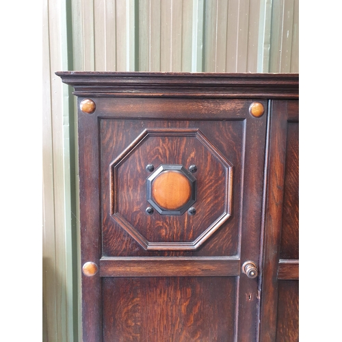 A panelled oak Wardrobe fitted doors with moulded decoration on a ...