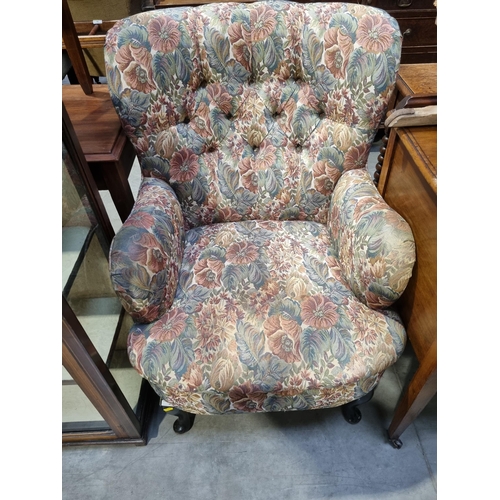 A button upholstered Easy Chair having a floral design on short ...