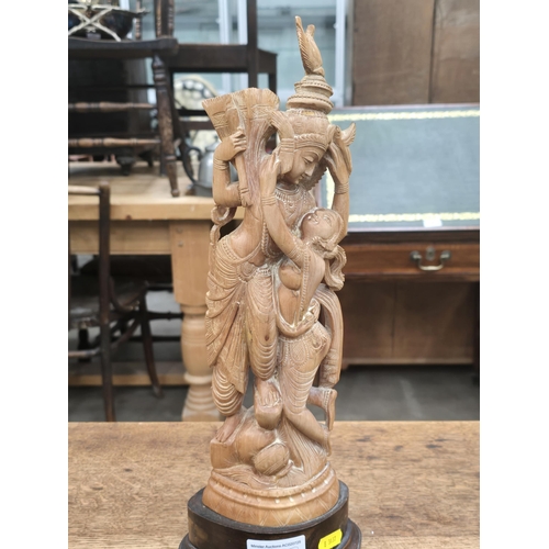 A carved wood Indian Figure Group on oval base, 17in H, and an Indian ...