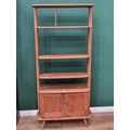 An Ercol elm Giraffe Room Divider with a fixed shelf above two ...
