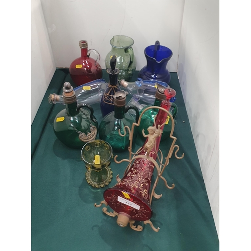 A red glass Cornucopia Wine Decanter on metal stand, four coloured ...