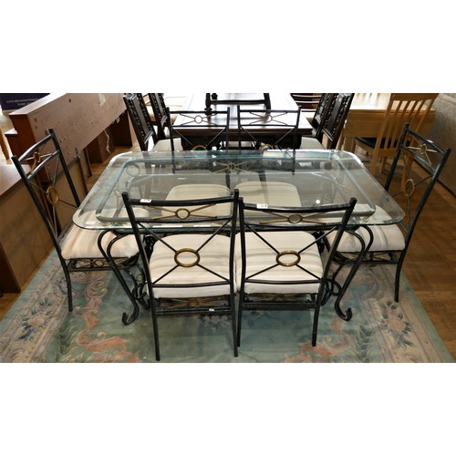 A wrought iron glass top dining table together with a set of six matching wrought iron dining chair