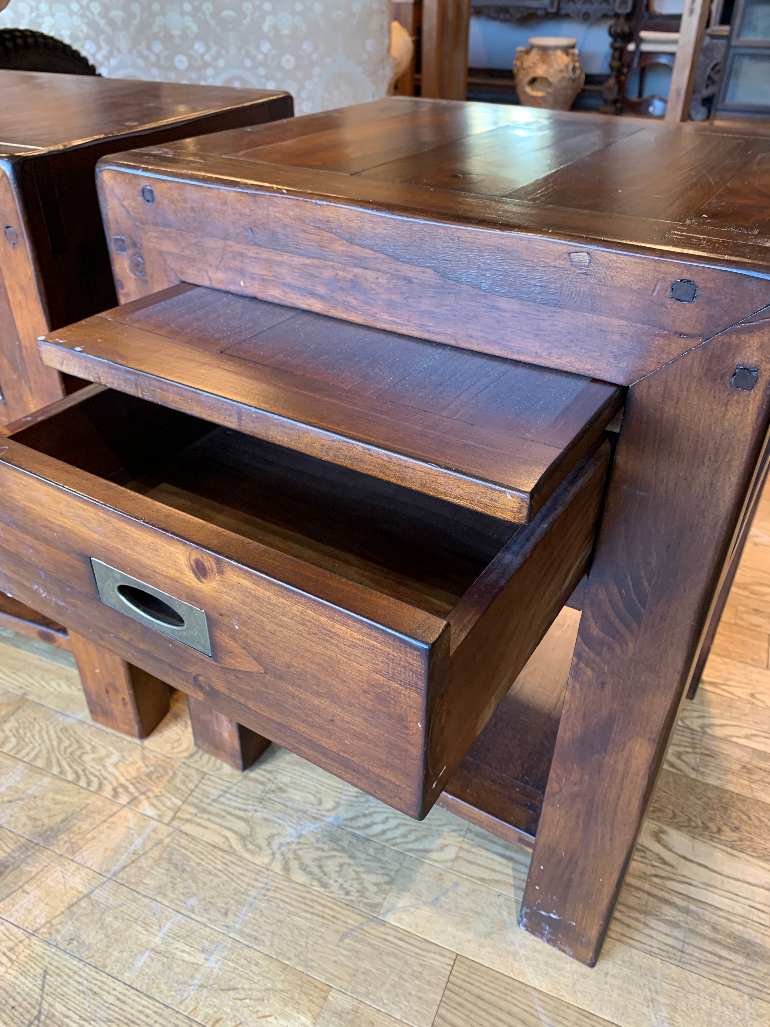 A pair of dark stained pine side tables, hidden pull out shelf over a ...