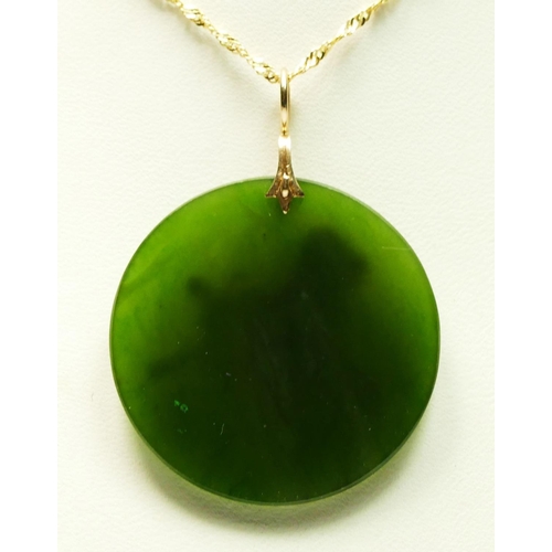 A 14K gold and nephrite jade disc pendant with applied horse motif ...