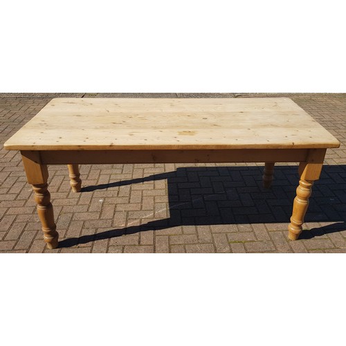 A rectangular pine country style kitchen table, raised on block and ...