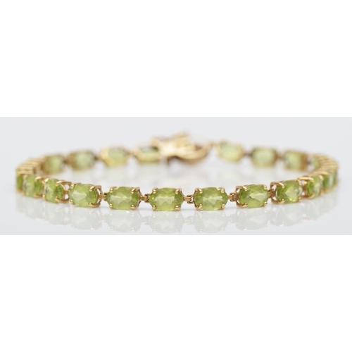 A 9ct gold and peridot line bracelet, diamond set clasp, 18.5cm, 5.2gm