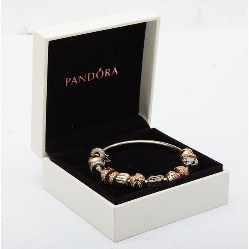 Pandora, a silver charm bangle with charms to include rose gold plated ...