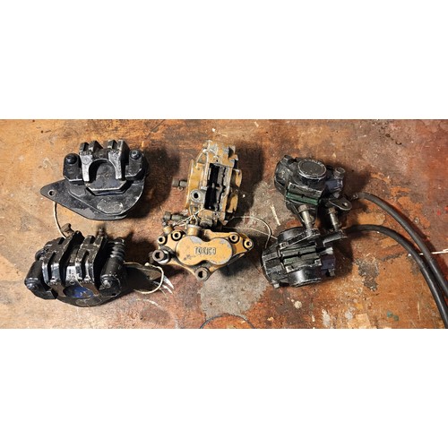 A pair of Tokico brake calipers in gold, a black pair, and a Aisin pair.