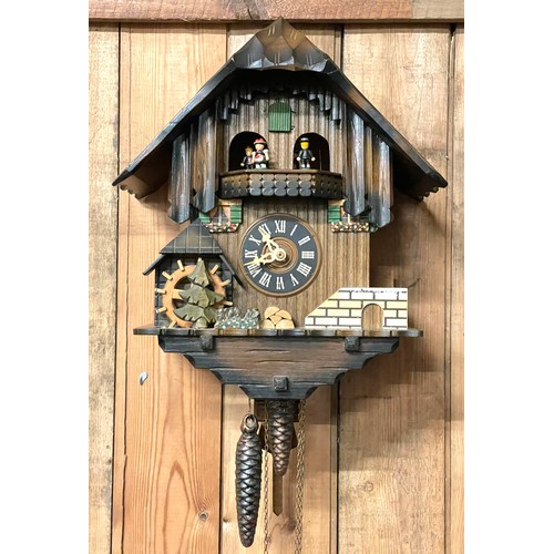 A 20th century painted cuckoo clock, with triple 'pine cones' weights ...