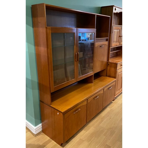 A mid 20th century teak wall/display unit, with twin glazed door ...