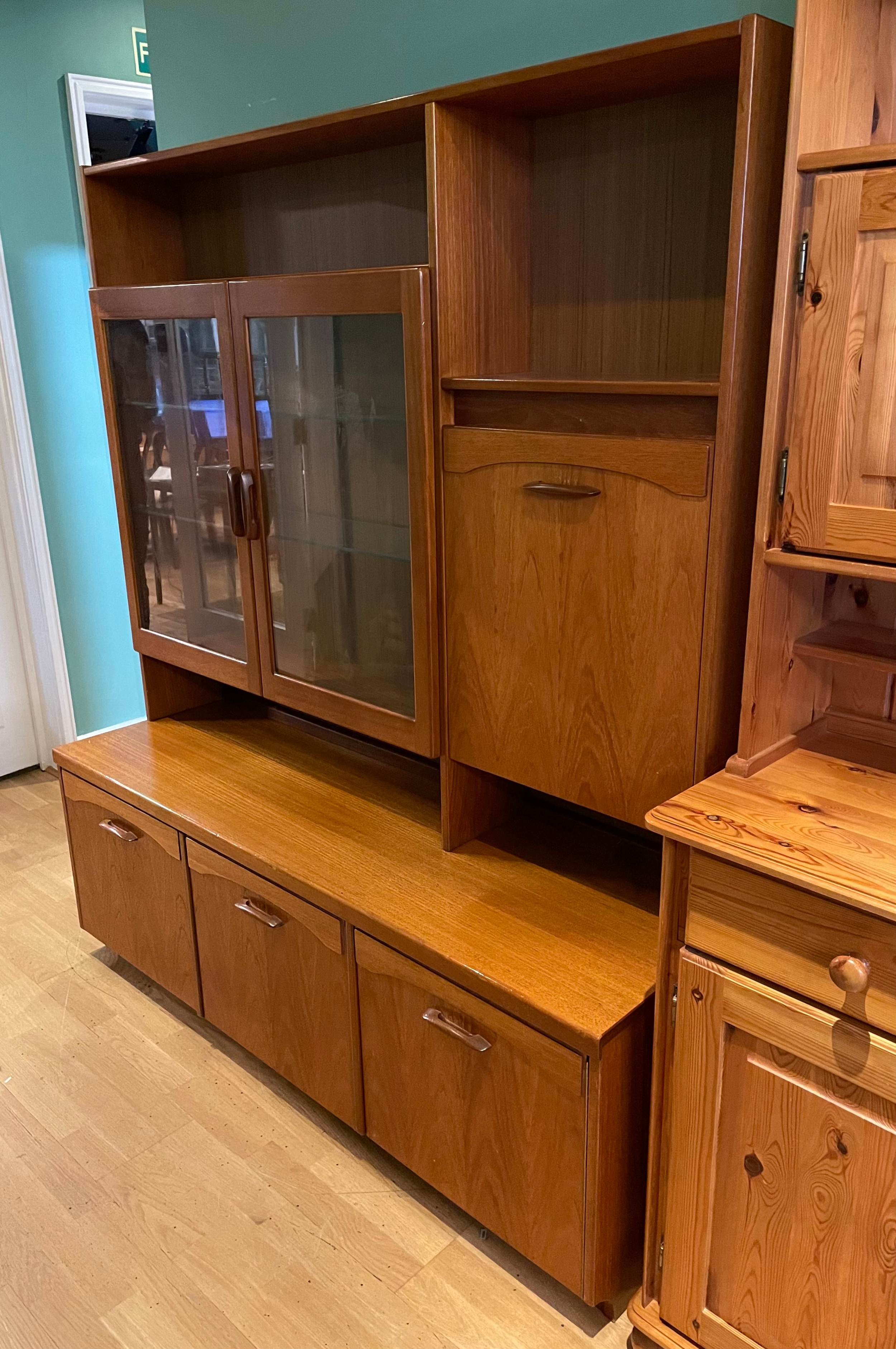 A mid 20th century teak wall/display unit, with twin glazed door ...