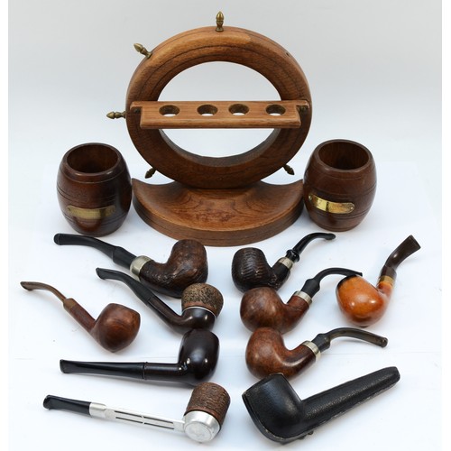 A collection of ten 20th Century smoking pipes, with a wooden stand and ...