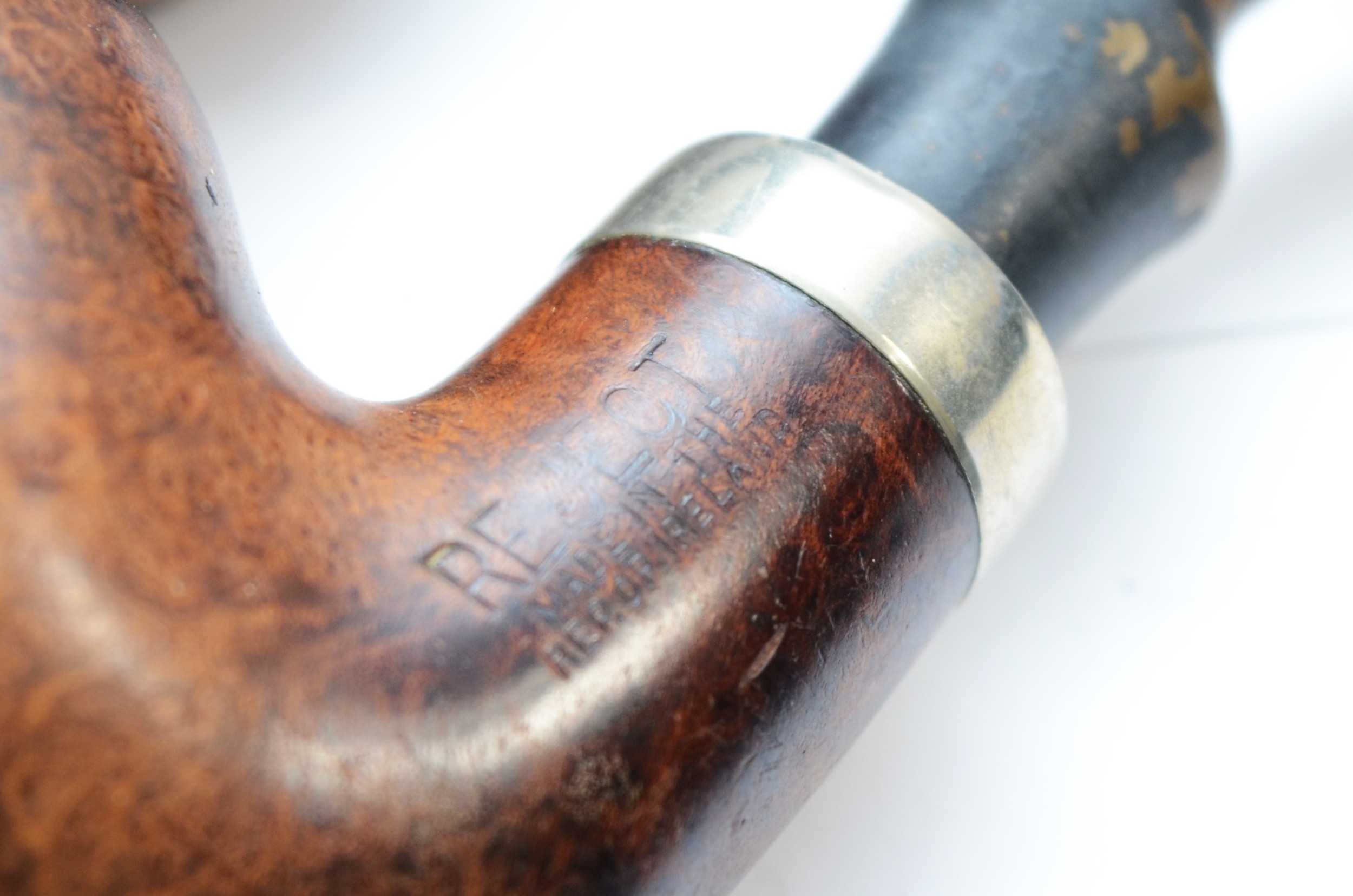 A collection of ten 20th Century smoking pipes, with a wooden stand and ...