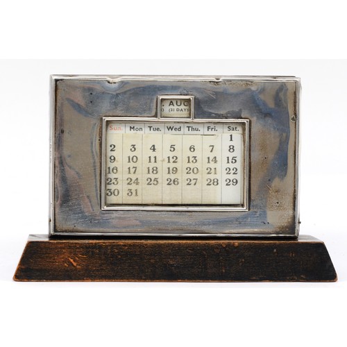 A silver desk calendar, Birmingham 1939, mounted on an ebonised stand ...