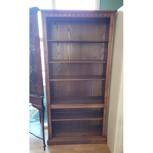 A contemporary Ercol 'Golden Dawn' elm open bookcase, having five adjustable shelves, raised on a pl