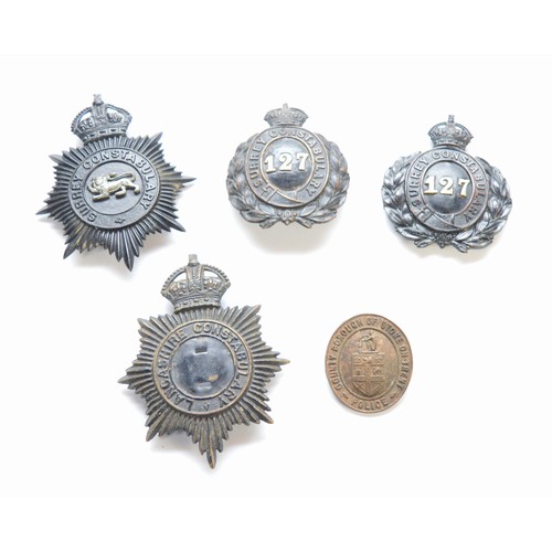 A collection of four police helmet plates, to include 127 Surrey ...