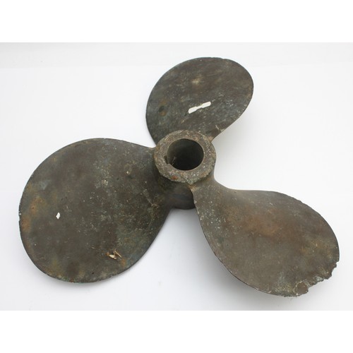 A salvaged three-blade bronze boat propeller, with central hub, each ...