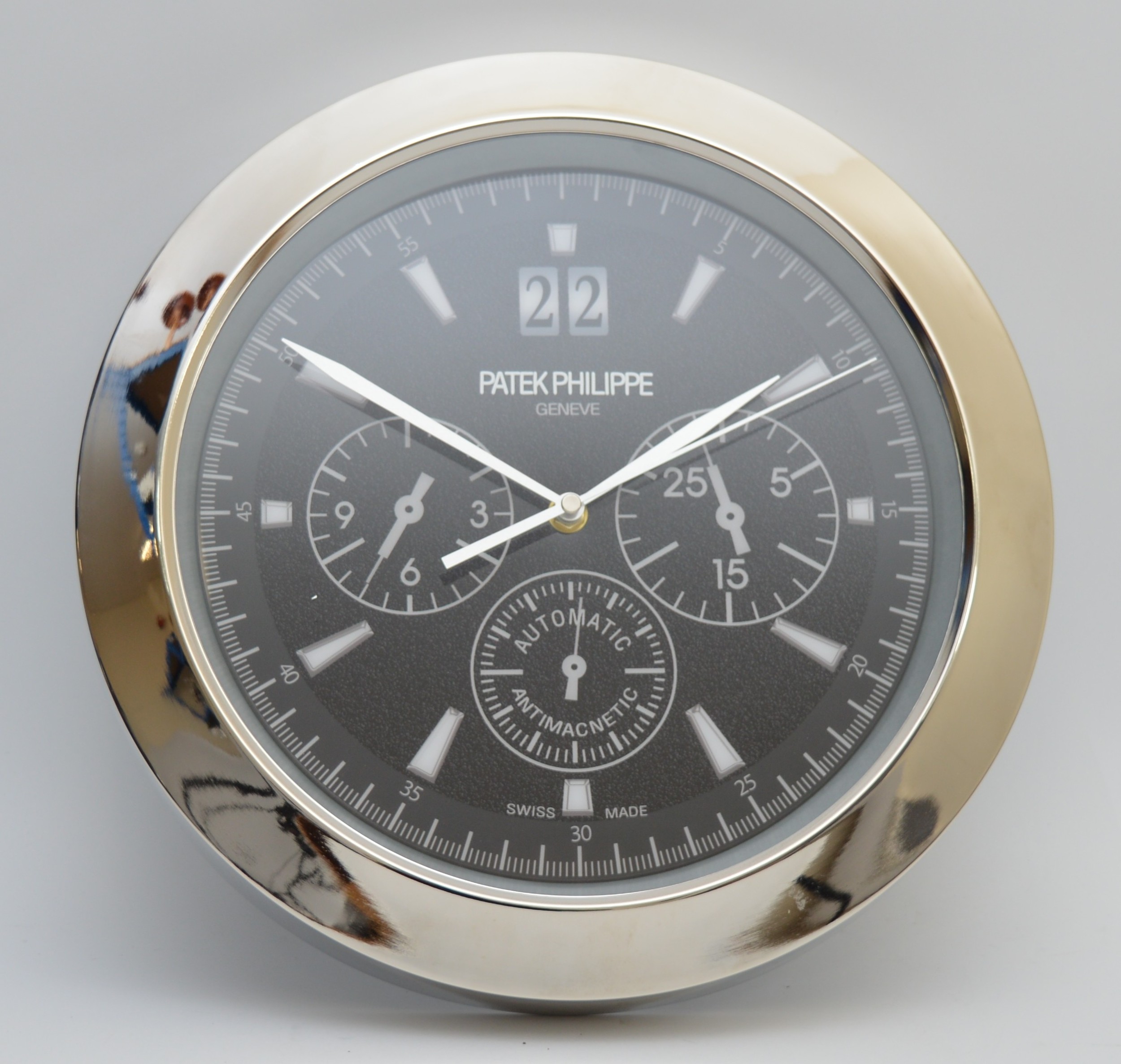 A 'Patek Philippe' style advertising metal wall clock, black dial and ...