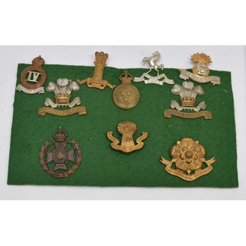 A collection of thirty five mounted mixed military cap badges and ...