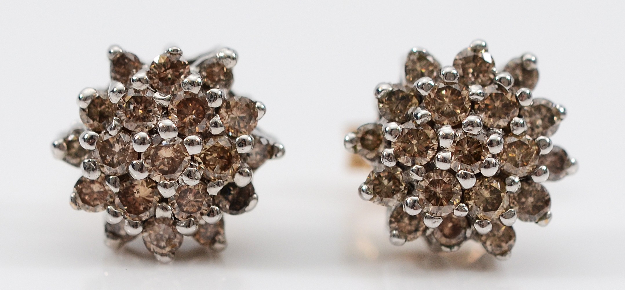 A pair of 9ct gold brilliant cut diamond cluster earrings with scroll ...