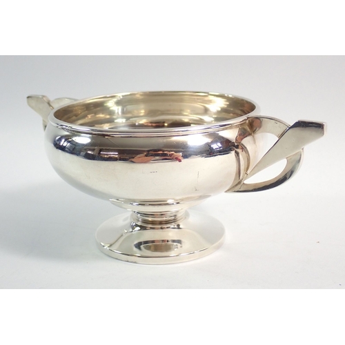 An Art Deco silver two handled cup with diagonal 'winged' handles on ...