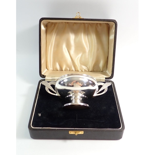 An Art Deco silver two handled cup with diagonal 'winged' handles on ...