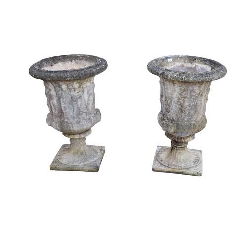 A pair of large composite stone garden urns. In the classical style ...
