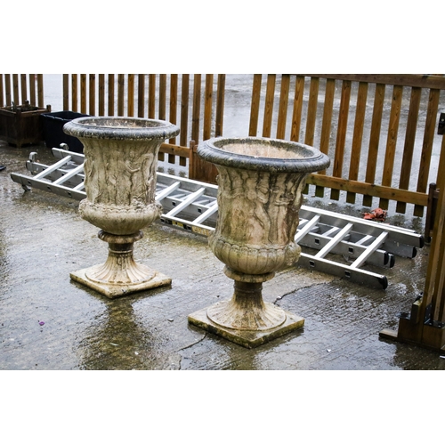 A pair of large composite stone garden urns. In the classical style ...