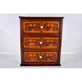A small wooden chest of drawers with blind fretwork decoration. Having ...