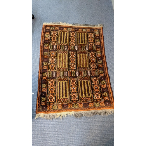 A handwoven Persian rug with symmetrical design, floral border on a red ...