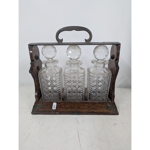 An Edwardian oak three-section Tantalus stamped 'Betjemanns' Location ...