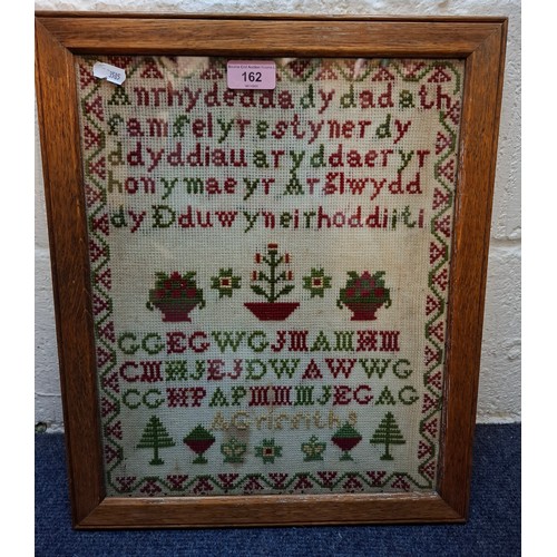 A mid 20th Century Welsh wool cross stitch sampler with religious verse ...