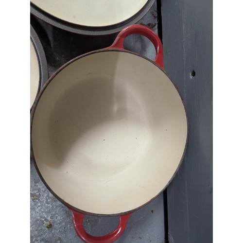 Le Creuset red enamelled pans to include a frying pan, a saucepan with ...