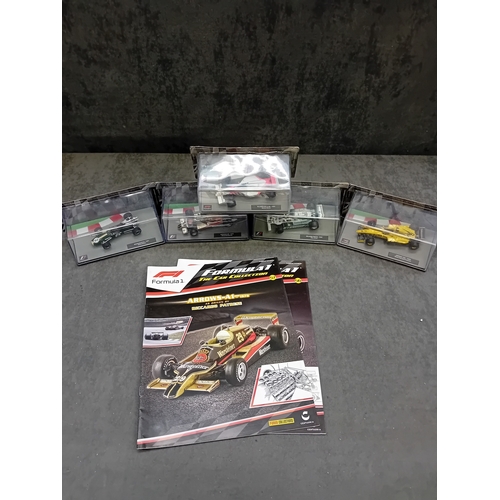 A collection of five die-cast metal and plastic scale model Formula 1 ...