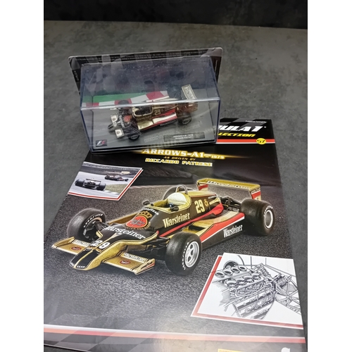 A collection of five die-cast metal and plastic scale model Formula 1 ...