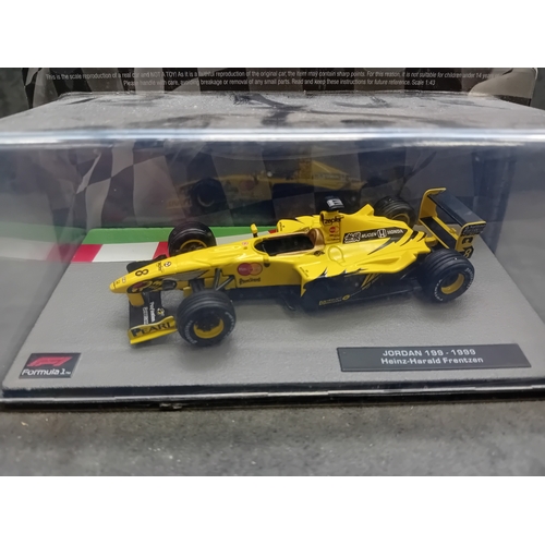 A collection of five die-cast metal and plastic scale model Formula 1 ...