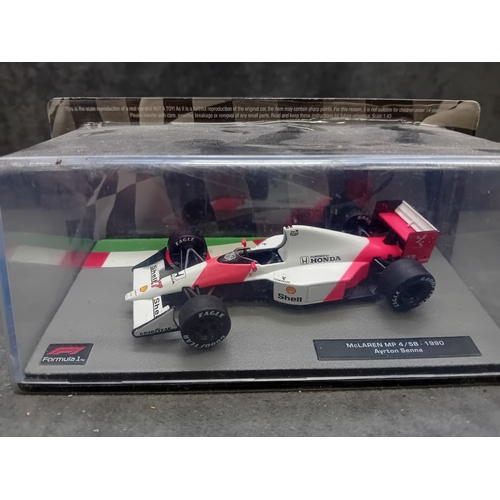 A collection of five die-cast metal and plastic scale model Formula 1 ...