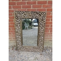 A vintage Eastern wall mirror within an ornately carved and pierced ...