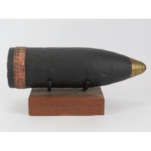 A WWI era British Howitzer shell. Mounted on a wooden display stand ...