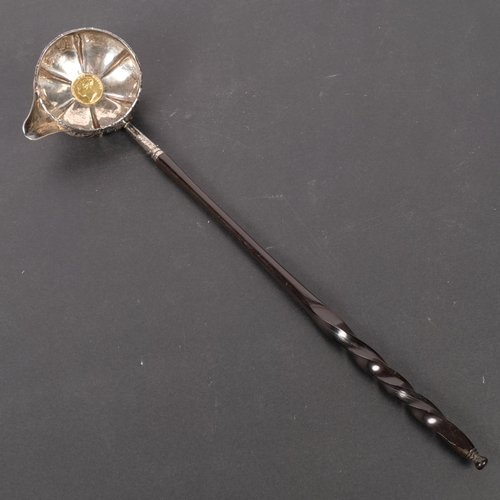 A Georgian silver toddy ladle with horn handle, the bowl inset with an ...