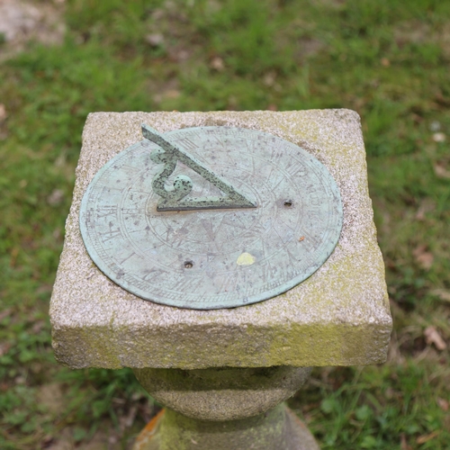 A weathered stone and copper sundial, height 84cm, width 30cm