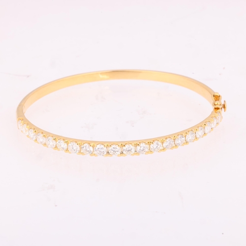 An 18ct gold diamond hinged bangle, claw set with modern round ...