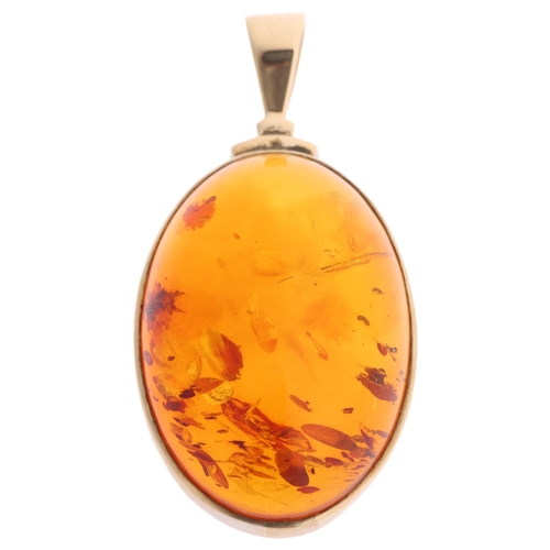 A 9ct gold amber pendant, rub-over set with oval cabochon am... | Barnebys