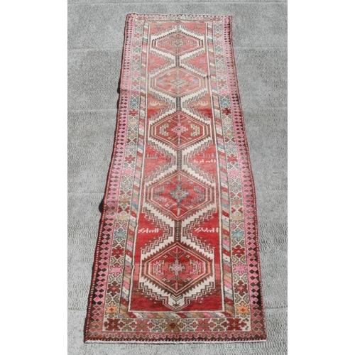 A Persian Azari runner with multiple hexagonal medallions on a beige ...