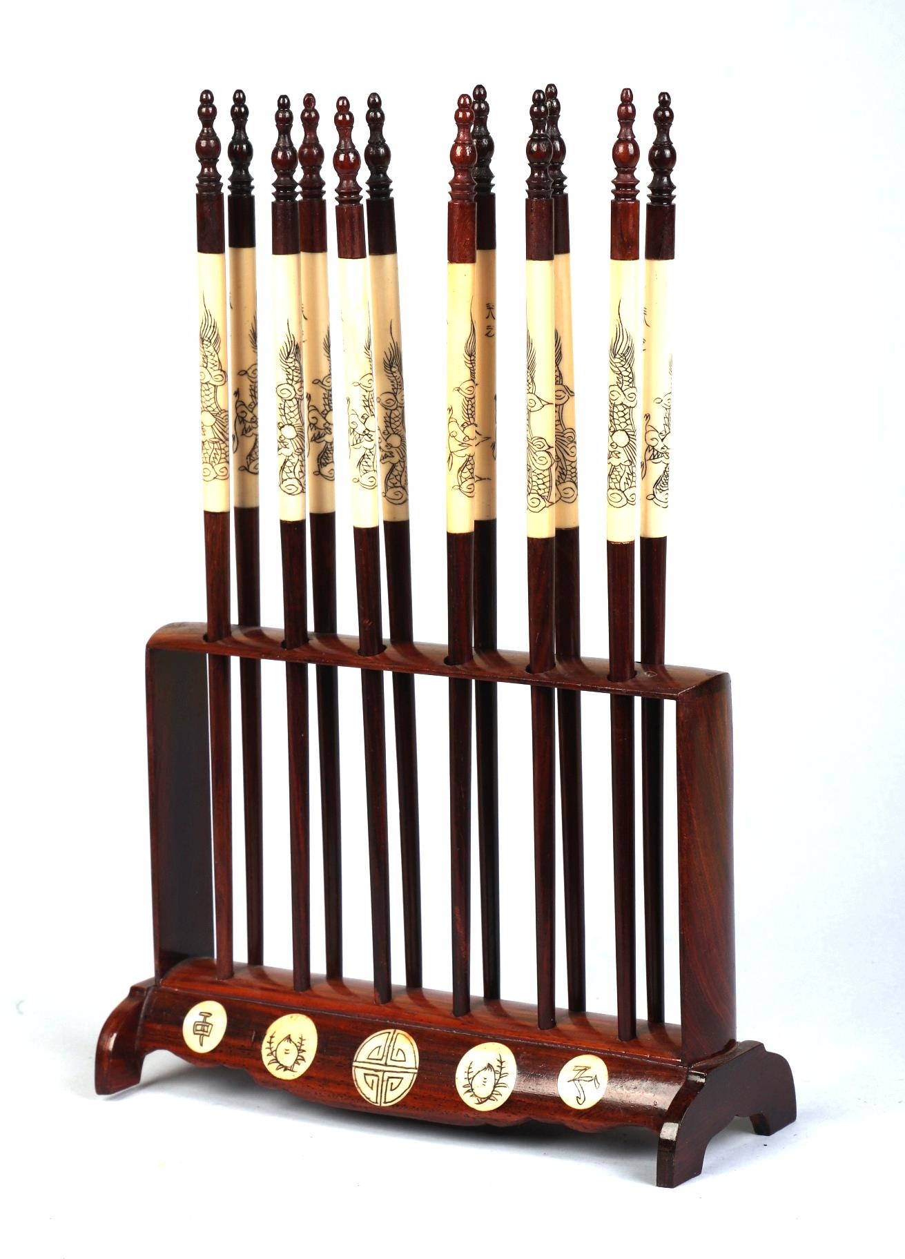 A Chinese hardwood chopstick stand holding six pairs of chopsticks with ...