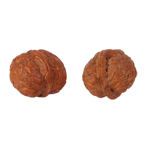 Two Chinese carved walnuts, each having profusely carved decoration (2).