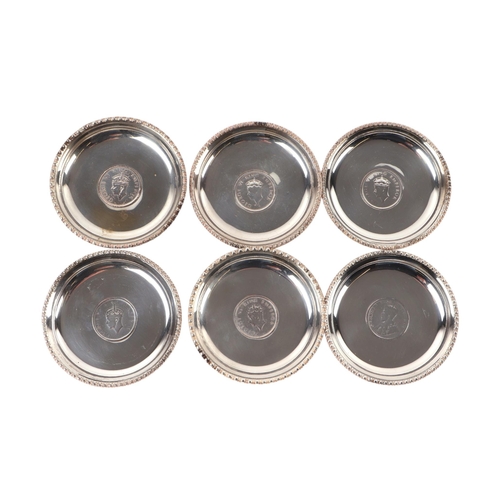 A set of six white metal coin set dishes, each set with a 1 1/4 Ana ...