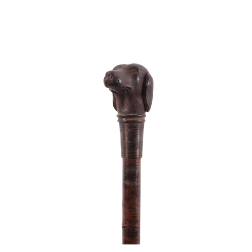 A Dog head skull crusher walking cane covered in leather washers, with ...